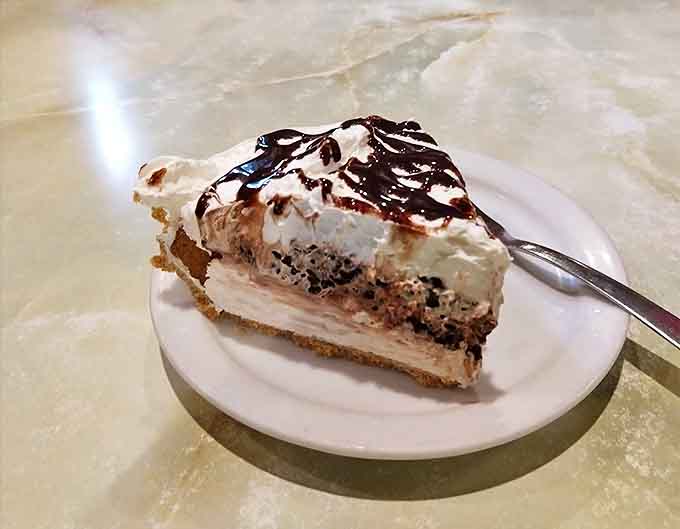The chocolate sour cream pie delivers that perfect balance of rich and tangy, crowned with a cloud of whipped cream and chocolate drizzle.