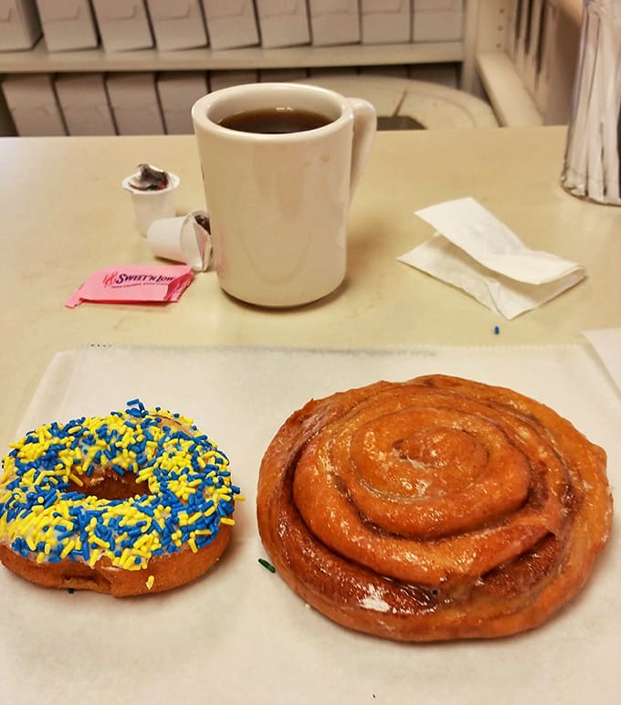 The perfect Michigan morning trifecta: strong coffee, a sprinkle donut in team colors, and a cinnamon roll that's basically a hug in pastry form.
