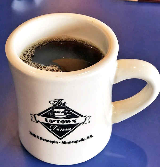 The coffee comes in sturdy mugs emblazoned with the diner's logo, offering liquid fortification for the breakfast adventure that awaits.