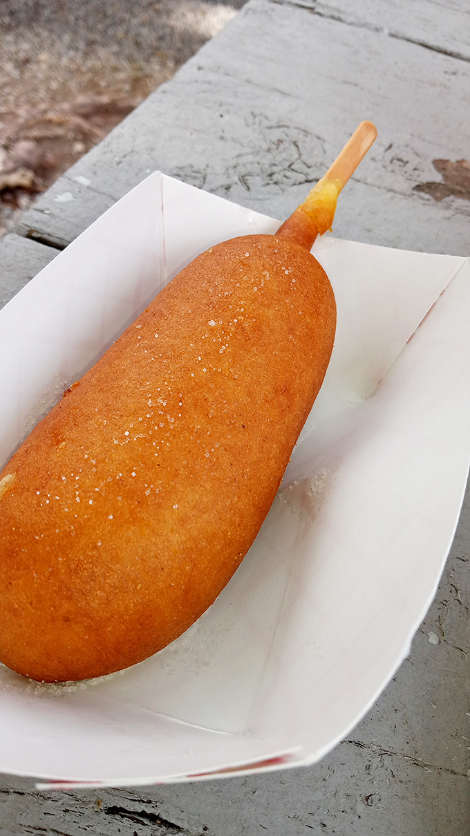 The golden-brown corndog offers a nostalgic taste of Americana, crispy outside and tender within.