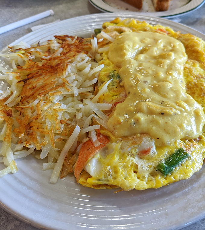 Savory breakfast perfection &ndash; a golden omelet blanketed in cheese alongside crispy hash browns demonstrates why breakfast is the day's most important masterpiece.