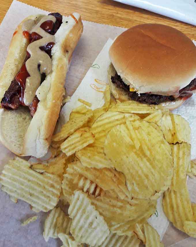 A classic American tableau: burgers, dogs, and chips arranged with unpretentious perfection on simple paper.