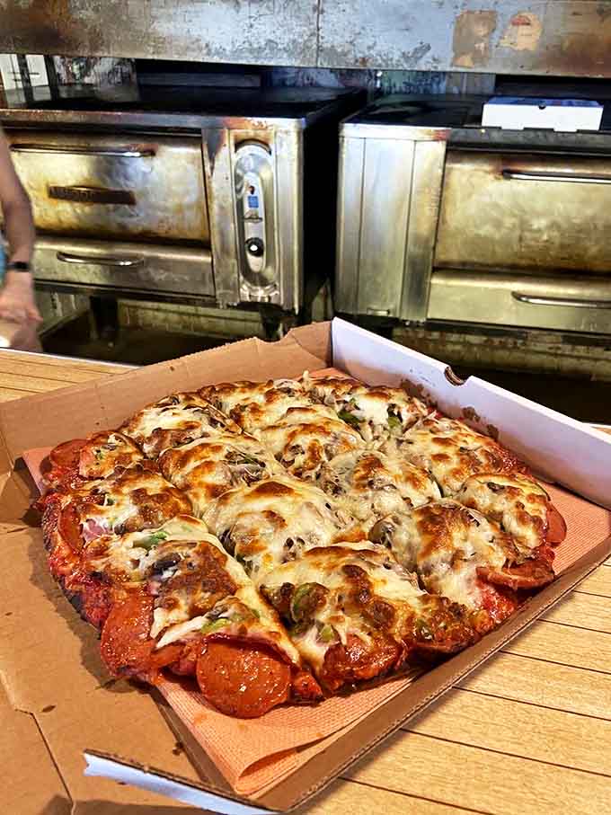 A freshly baked deluxe pizza awaits its destiny, the melted cheese and colorful toppings promising a symphony of flavors.