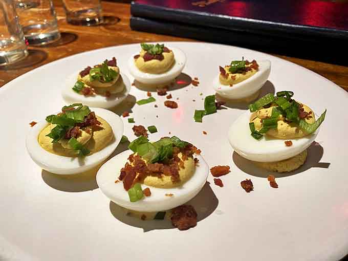 Deviled eggs get the speakeasy treatment with bacon crumbles and fresh chives &ndash; the perfect savory companion to balance sweet cocktails.