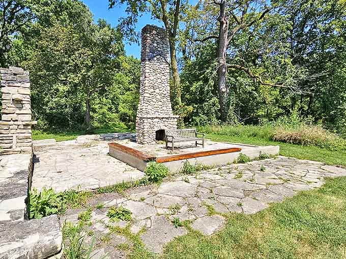 This stone fireplace stands as a silent sentinel to bygone days, its weathered facade telling stories of gatherings and warmth amid the wilderness.