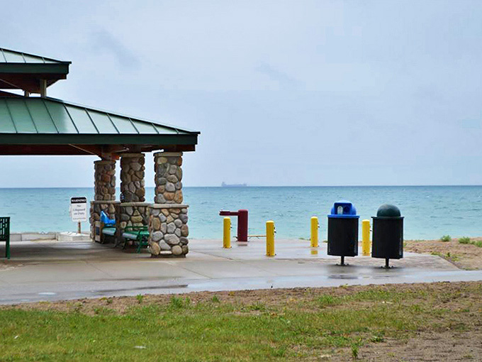 The vast expanse of Lake Huron stretches to the horizon, where the gentle silhouettes of beachgoers become part of the landscape.