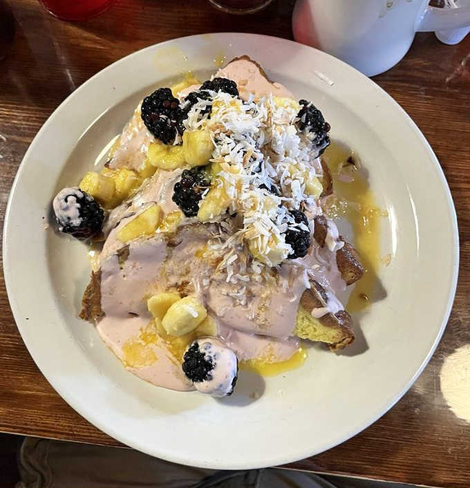 French Toast: Breakfast alchemy at its finest &ndash; bread transformed into a sweet canvas for berries, bananas, and what appears to be a drizzle of pure joy.