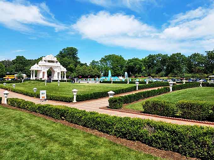 The meticulously maintained gardens create a serene oasis, where geometric hedges and fountains complement the temple's architectural precision.