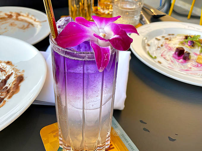 This isn't just a pretty purple drink &ndash; it's liquid art that tastes as magnificent as it looks, garnished with an orchid that's almost too beautiful to disturb.