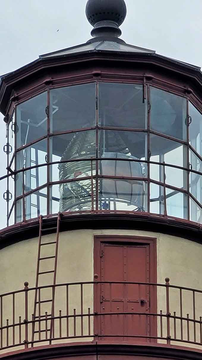 Inside the lantern room, the massive Fresnel lens still stands ready for duty, a glass masterpiece that once projected light 21 miles across Lake Michigan's unpredictable waters.