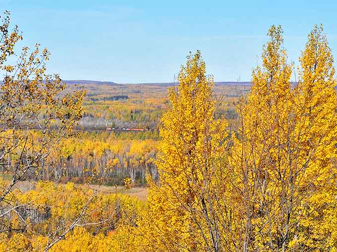 Fall's golden touch transforms the forests surrounding Leonidas into a painter's palette, creating a fiery contrast against the blue waters below.
