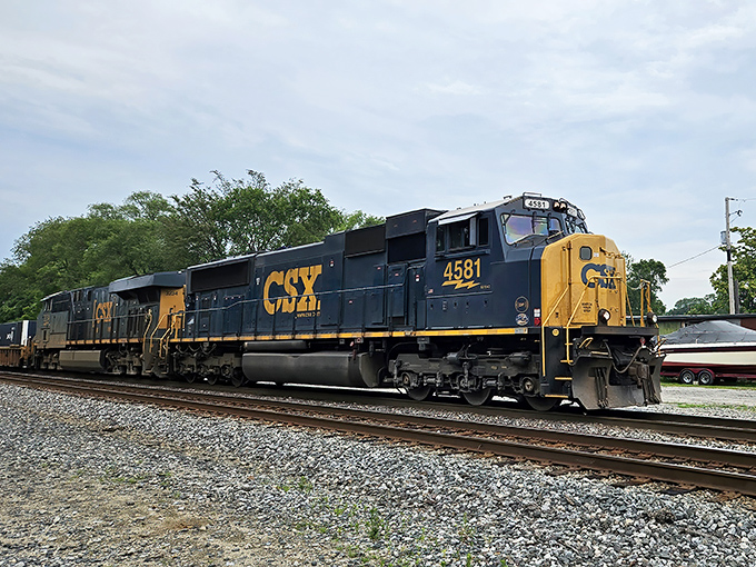 A powerful CSX locomotive drives a long container train through Fostoria, keeping America&rsquo;s commerce moving from coast to coast.