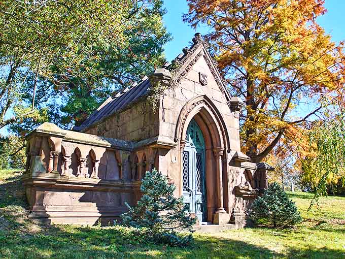 Autumn leaves frame this elegant mausoleum, its arched doorway looking like the entrance to a storybook sanctuary.