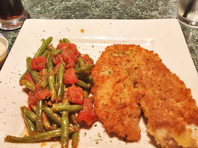 Comfort food perfection at Muglys, crispy breaded cutlet beside garlicky green beans, proving Michigan knows hearty dinners done right tonight.