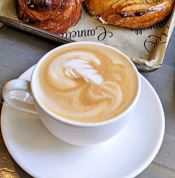 Steam rises from this artfully crafted latte like a morning meditation &ndash; the perfect liquid companion to buttery pastry indulgence.