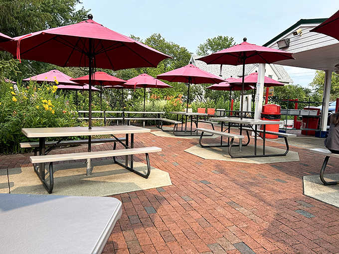 The outdoor patio, with its cherry-red umbrellas, transforms ordinary Tuesday lunches into mini-vacations from the modern world.