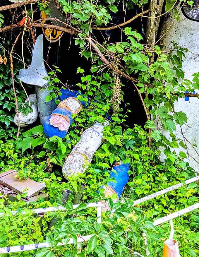 Mannequin limbs and mysterious objects peek through the greenery, creating unexpected encounters throughout the property.