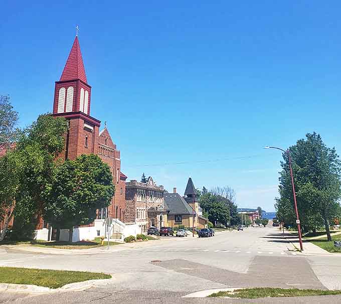 Sacred Heart Catholic Church's distinctive red steeple punctuates Munising's skyline, a spiritual landmark that's witnessed generations of local history.