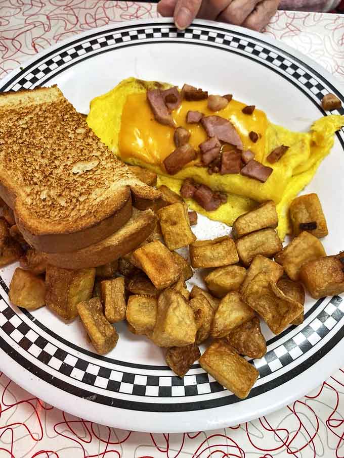 Omelet artistry: Fluffy eggs wrapped around ham and cheese with perfectly crisped edges &ndash; breakfast architecture at its finest.