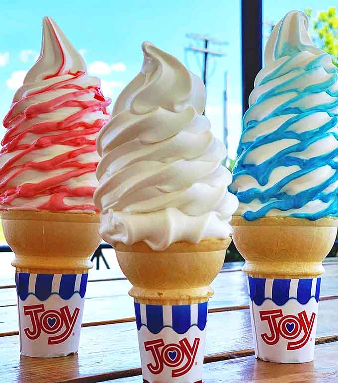 The soft-serve trinity: three perfect swirls of ice cream artistry that defy both gravity and willpower with their colorful drizzles.