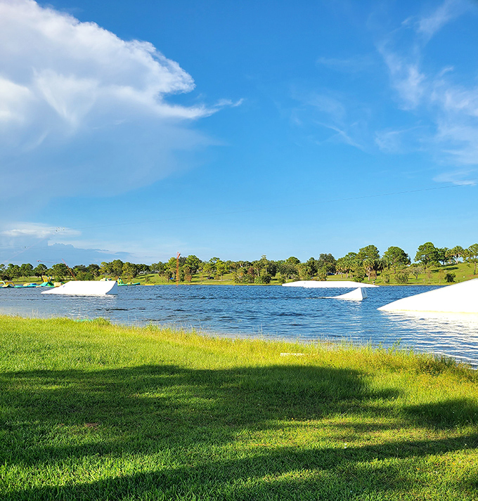 Summer perfection captured: The wakeboarding lake stretches toward the horizon, framed by Florida's signature palm trees and impossibly blue skies.