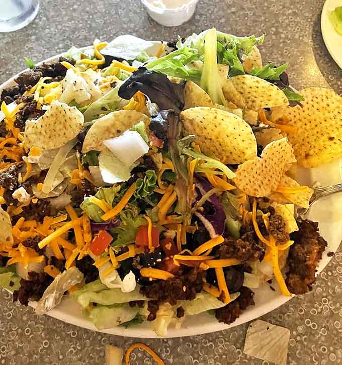 The taco salad arrives as a mountain of fresh ingredients &ndash; seasoned beef, crisp lettuce, cheese, and crunchy tortilla chips that somehow makes healthy feel indulgent.
