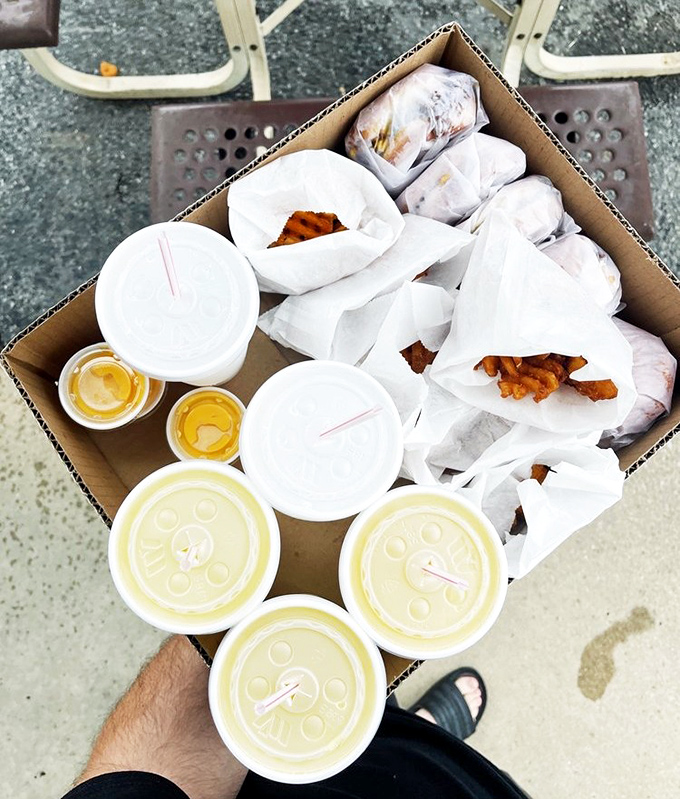 The family feast arrives! Nothing says "we're making memories today" like a cardboard box filled with burgers, fries, and happiness.