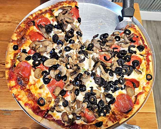 Black olives and mushrooms create a classic topping combination that proves sometimes the simplest ingredients make the most satisfying pizza.