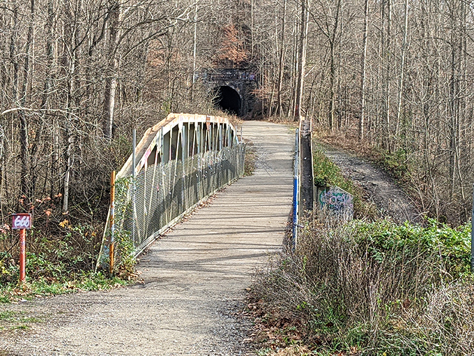 A wooden bridge guides hikers across a stream, part of the trail system connecting to the historic tunnel.