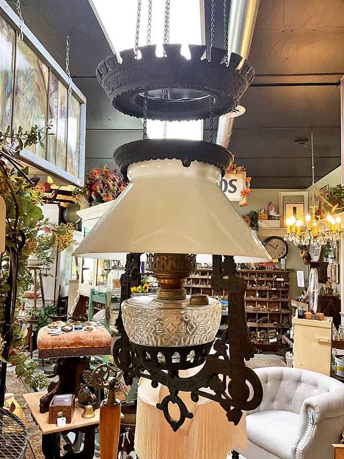 This magnificent cast-iron kerosene hanging lamp transforms any space with its amber glow, craftsmanship from an era when lighting was both functional art and necessity.