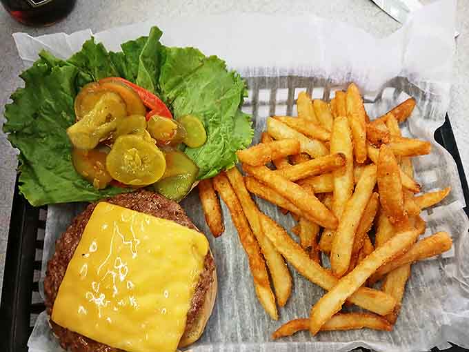 This isn't just a cheeseburger – it's architecture on a bun, with layers of beef, cheese, and fresh toppings creating a savory skyscraper.