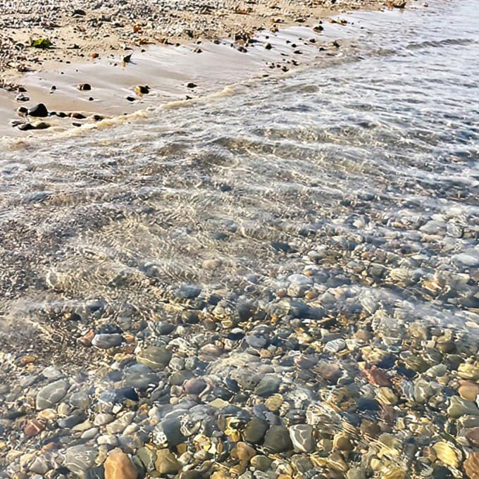 Crystal-clear water reveals the rocky bottom, giving swimmers advance warning of what they're about to step on with their bare feet.