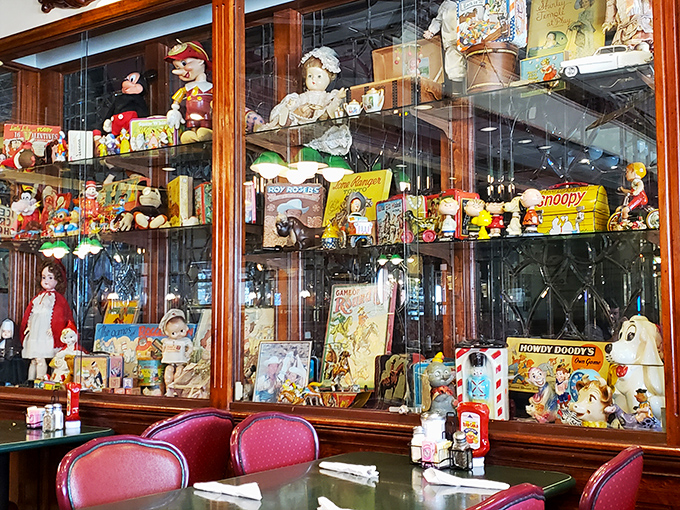 Vintage toys and collectibles stand at attention behind glass, creating a nostalgic backdrop that transports diners to simpler times.