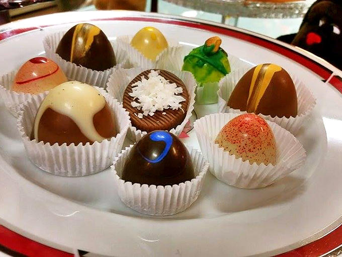 Handcrafted chocolate truffles arranged like edible jewelry, each one a miniature masterpiece too beautiful to eat but too tempting not to.