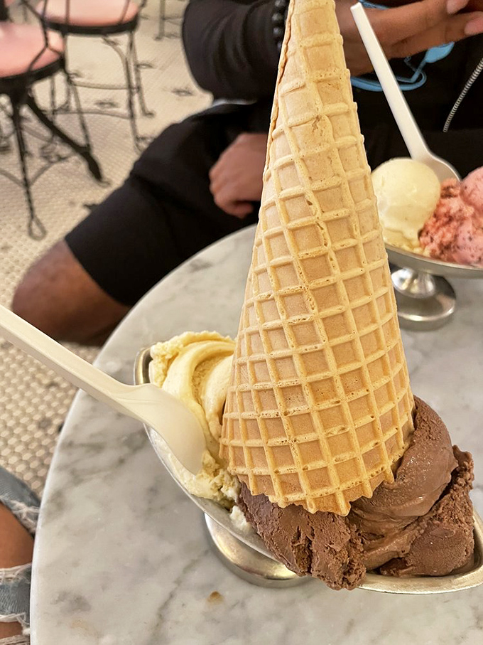 Ice cream architecture at its finest &ndash; a perfectly constructed cone showcasing the ideal ratio of flavors that makes choosing just one scoop nearly impossible.