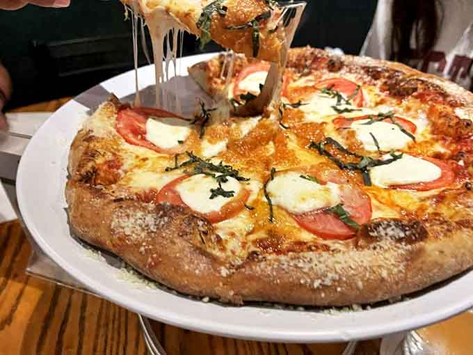 Sometimes simplicity is the ultimate sophistication &ndash; fresh basil, bright tomatoes, and melty cheese on a wood-fired canvas of deliciousness.