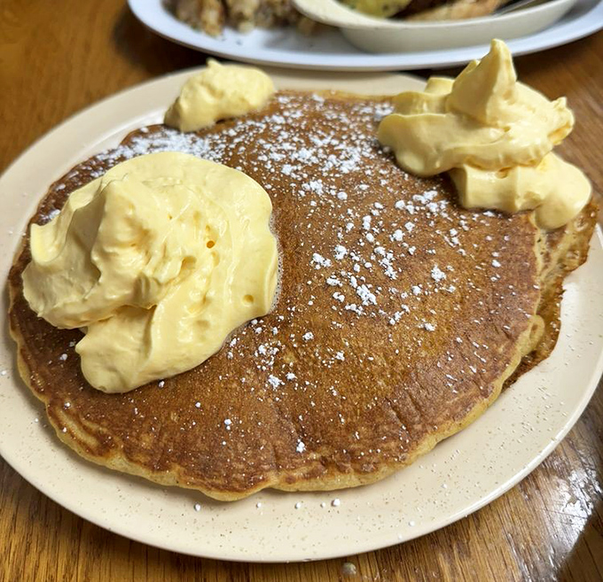 Pancakes so fluffy they could double as pillows, topped with butter dollops melting into golden breakfast perfection.