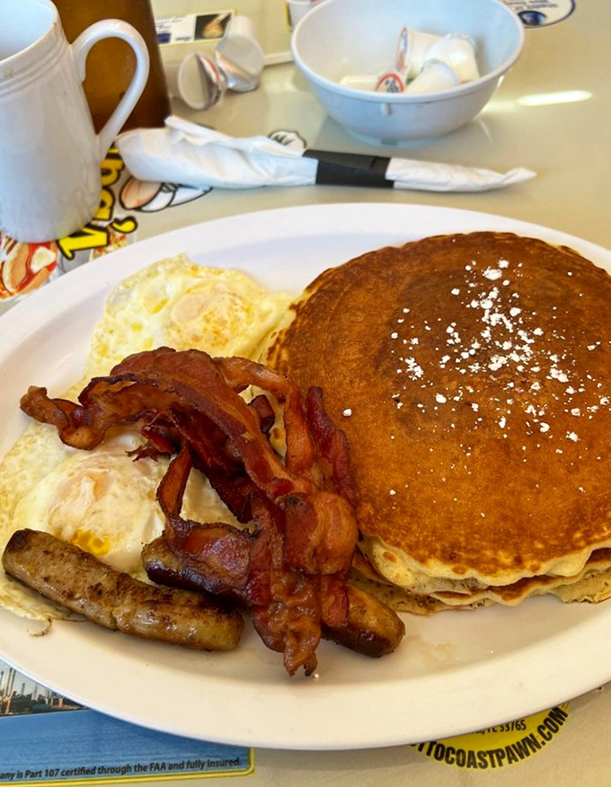 The holy trinity of breakfast perfection: golden pancakes, eggs your way, and bacon that's achieved that magical balance between crispy and chewy.