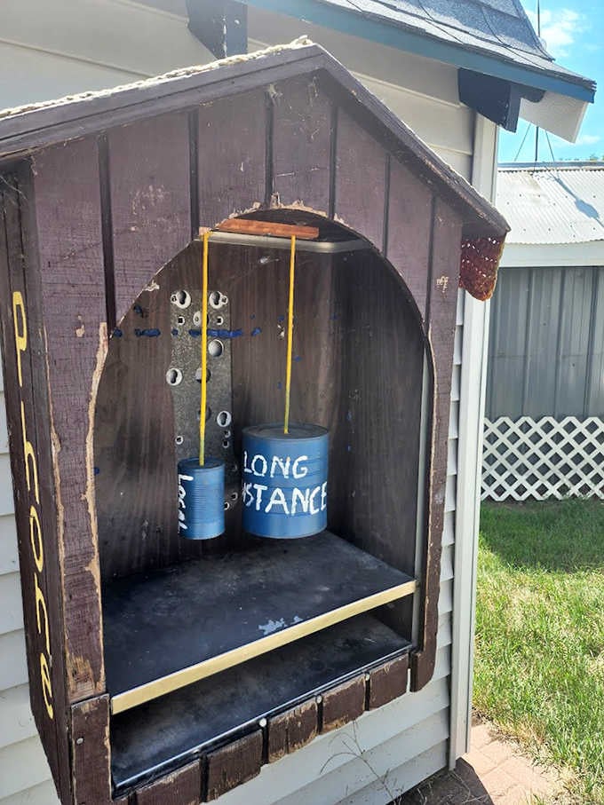 This vintage telephone booth-inspired outhouse offers "Long Distance" communication from an era before smartphones ruled our lives.