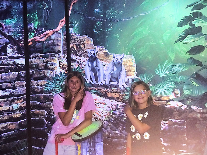 Young adventurers pose with jungle creatures, their smiles as bright as the ultraviolet surroundings &ndash; memories being made in real time.