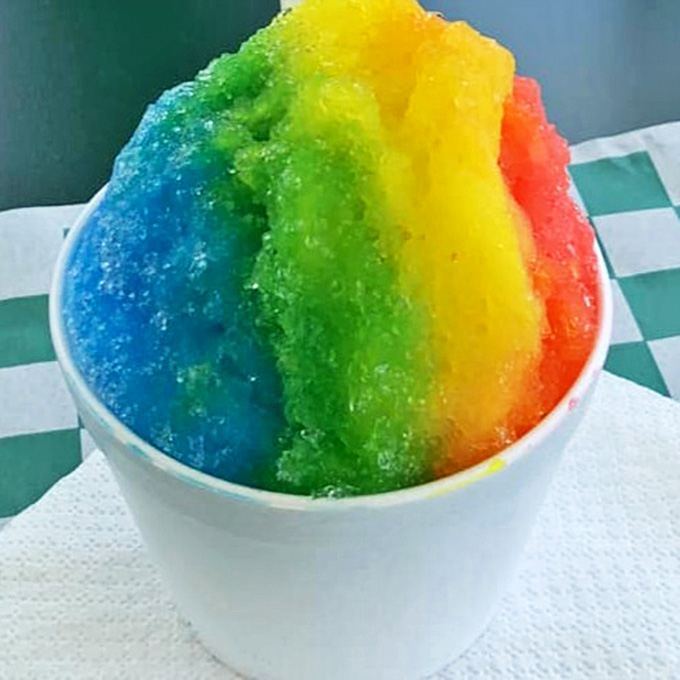 This rainbow shaved ice looks like a unicorn sneezed in the best possible way, offering sweet, icy relief on hot days.