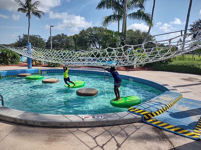 Young adventurers navigate the rope course and floating platforms, demonstrating that falling with style is an underappreciated art form.