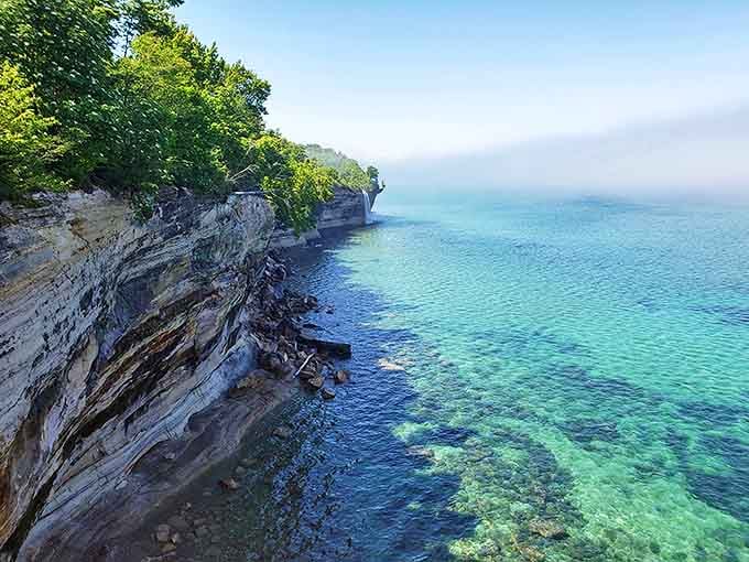 The layered sandstone tells geological stories spanning millions of years, while the turquoise water provides the perfect frame for this masterpiece.