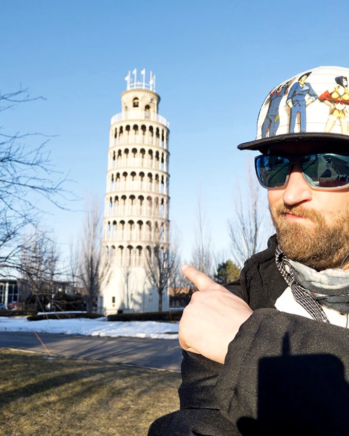 A visitor gives the tower a thumbs-up, participating in the time-honored tradition of playful perspective photos that this tilting landmark inspires.