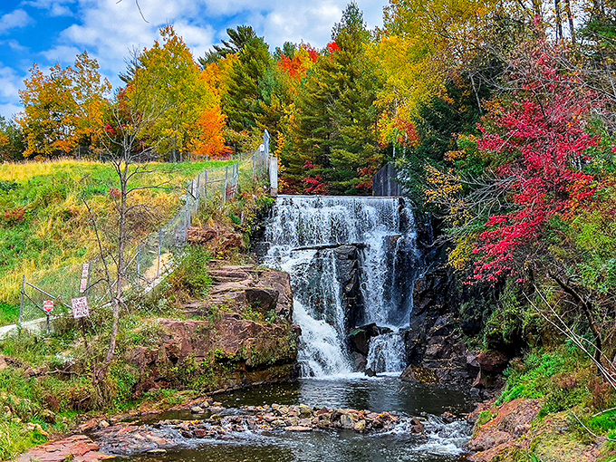 Lake Redstone Waterfall cascades over vibrant red sandstone, creating a striking color contrast that photographers can't resist capturing.