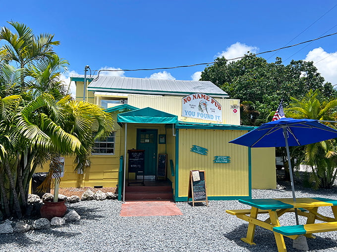 No Name Pub's cheerful yellow exterior stands out against the tropical foliage. The unassuming building houses one of the Keys' most unique dining experiences.