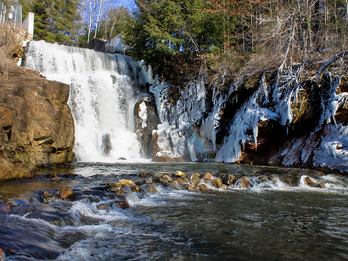 Winter transforms Lake Redstone Waterfall into a frozen wonderland, where ice formations frame the sections of still-flowing water.