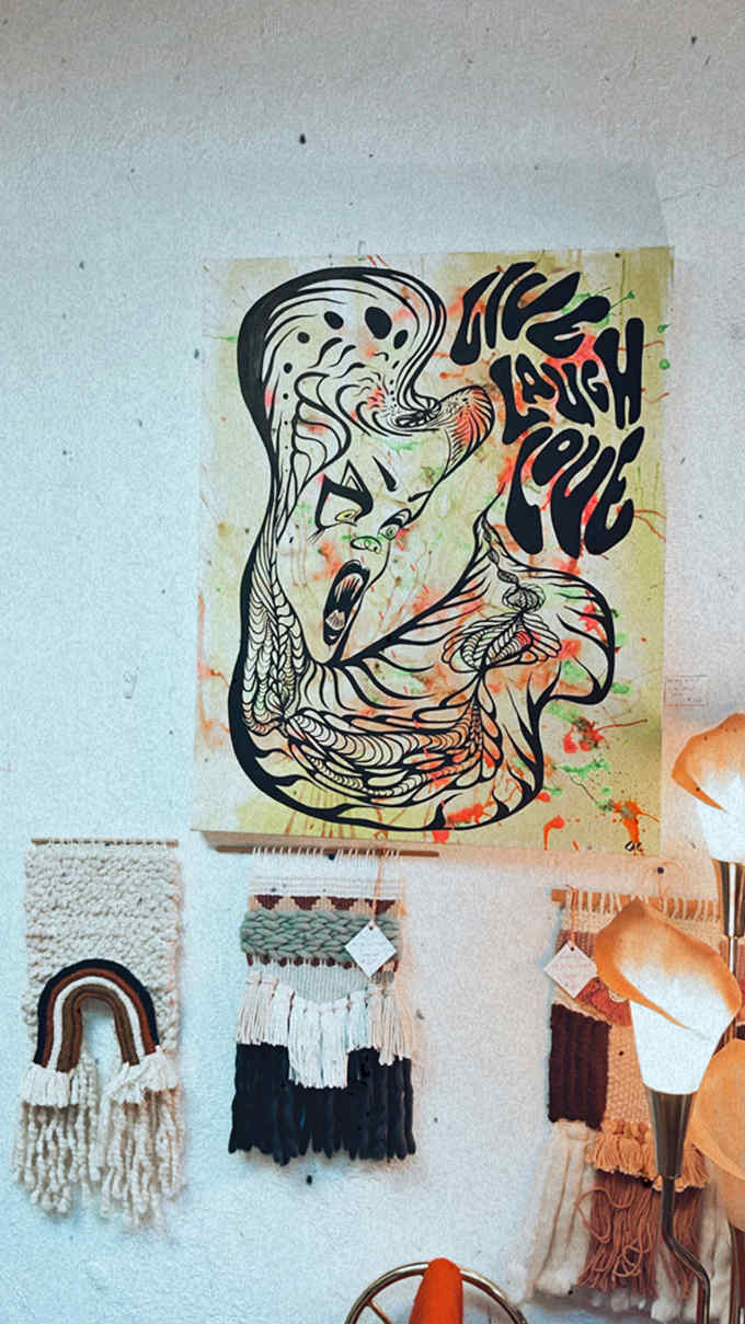 Bold lines and vibrant colors dance across this statement piece, while handcrafted fiber art adds textural whispers below.