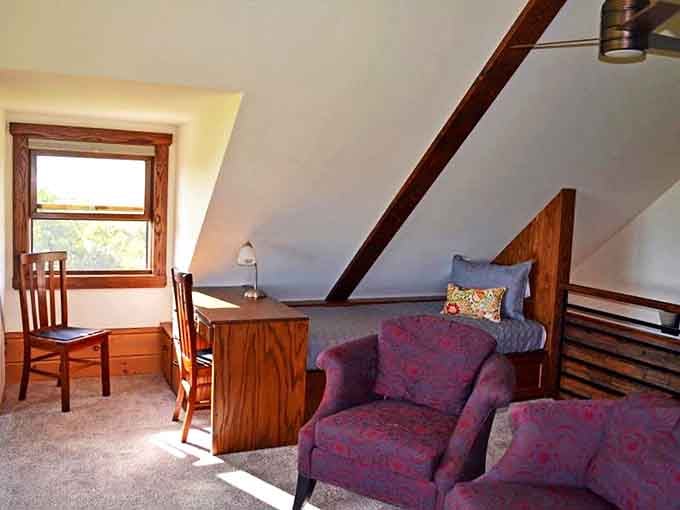 The upstairs bedroom tucked under sloping eaves creates a nest-like retreat where worries dissolve and restoration begins with each peaceful night.