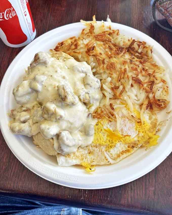 Biscuits drowning in sausage gravy next to crispy hash browns and eggs, this plate understands the assignment and aces the test.